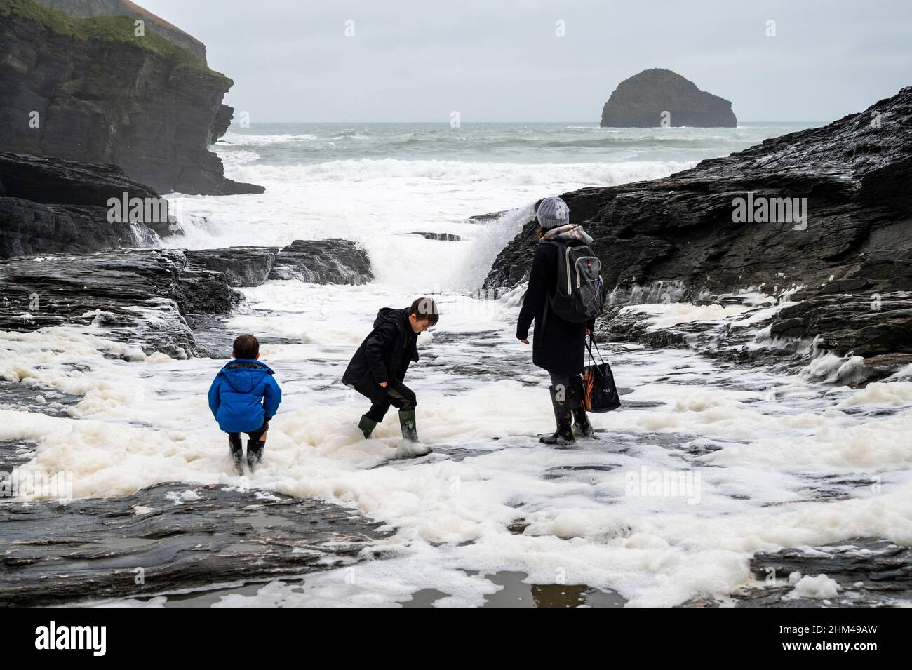 Trebarwith Strand, Cornwall, UK, in winter with children playing in sea ...