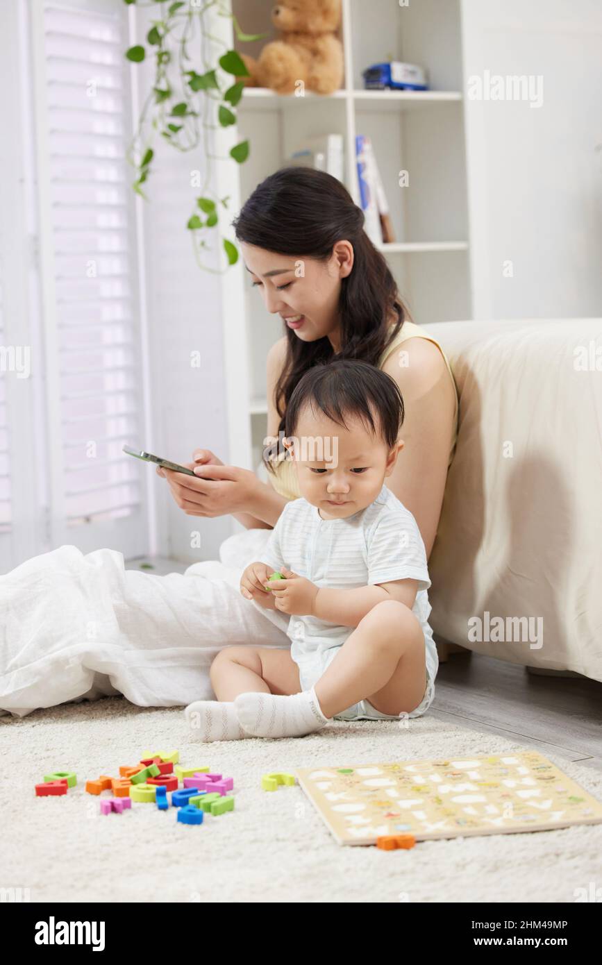 The use of mobile phones with the baby to play the young mother Stock ...