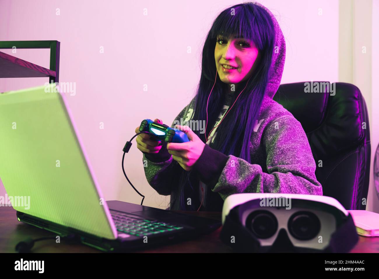 Caucasian girl in her 20s playing computer game using gamepad ...