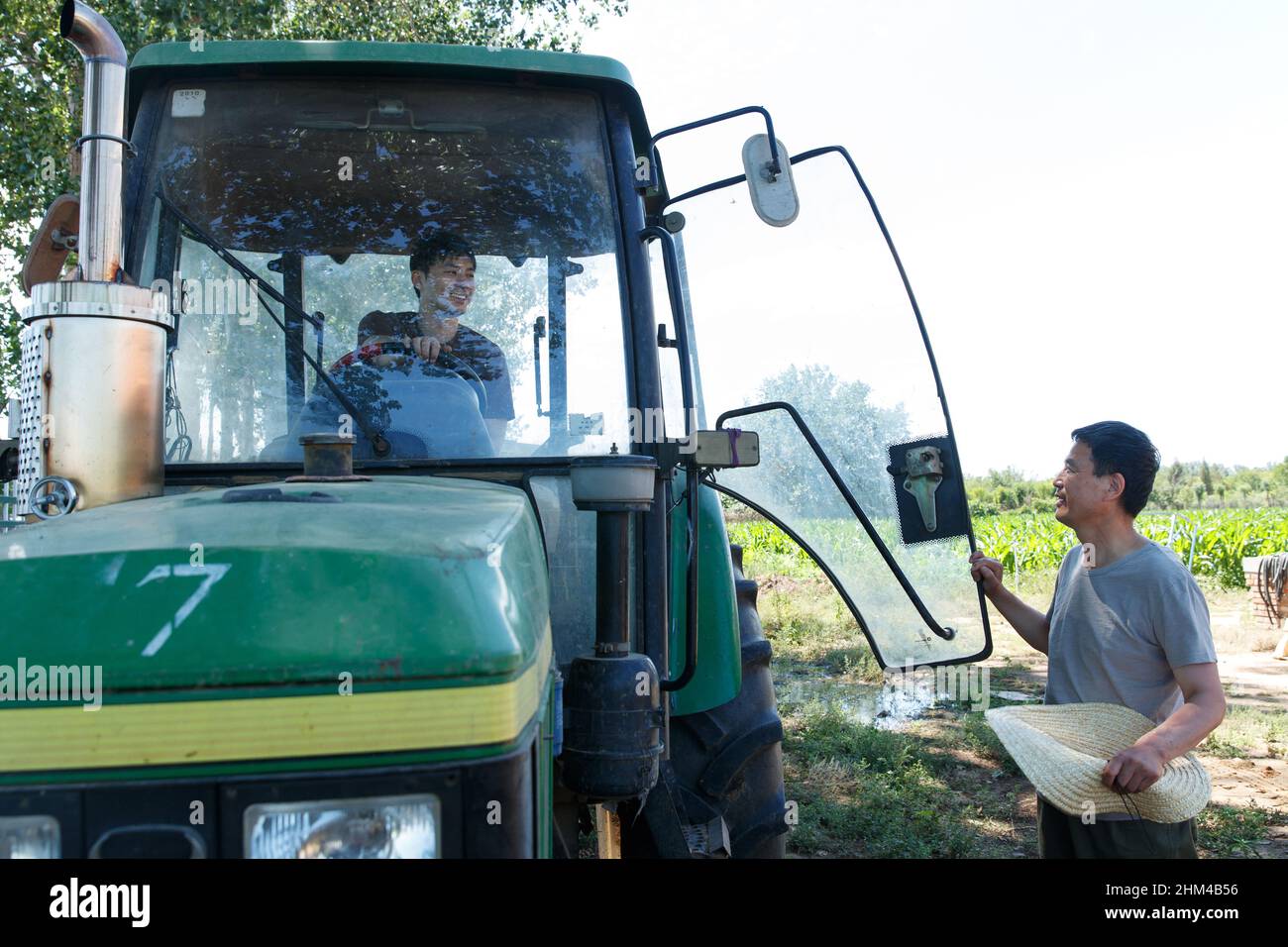 Farmers chat beside the harvester Stock Photo - Alamy