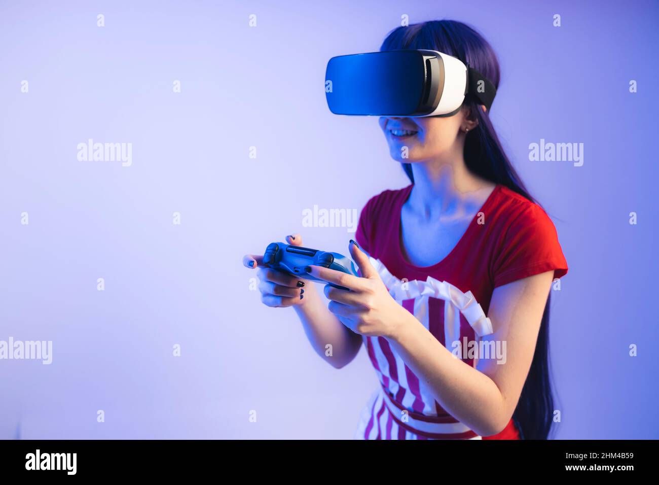 Teenage caucasian girl gamer wearing VR goggle set playing a game match ...