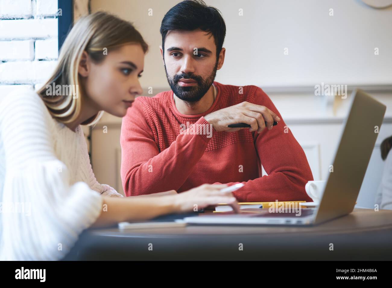 Serious friends working together in cafeteria Stock Photo - Alamy