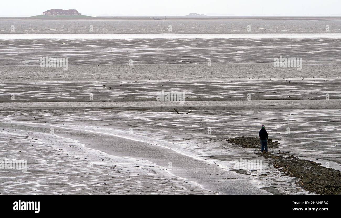 Nordstrand, Germany. 07th Feb, 2022. Passers-by stand on a groyne in ...