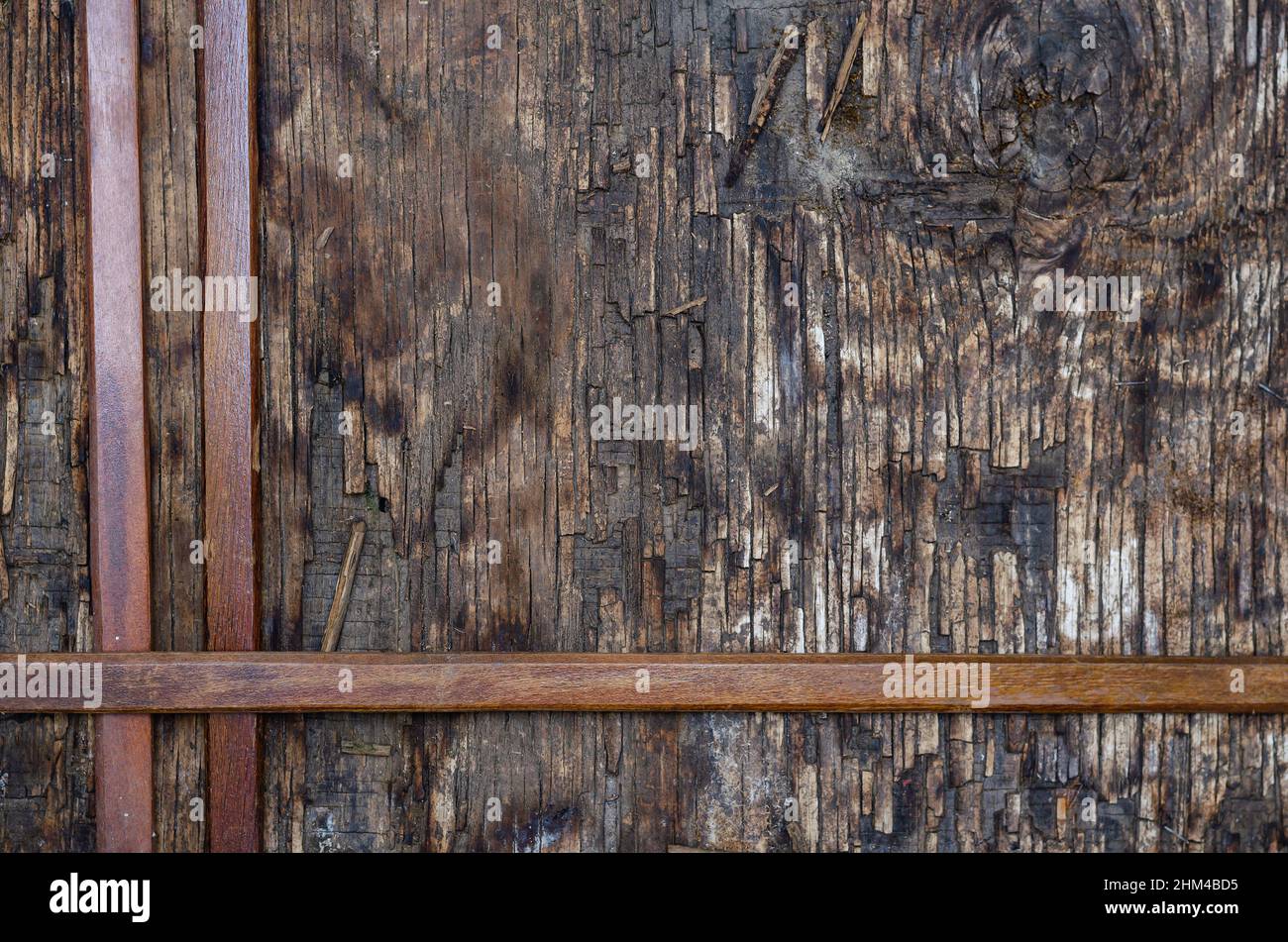 Three narrow wooden slats on a dark wooden background. Cracked wooden ...