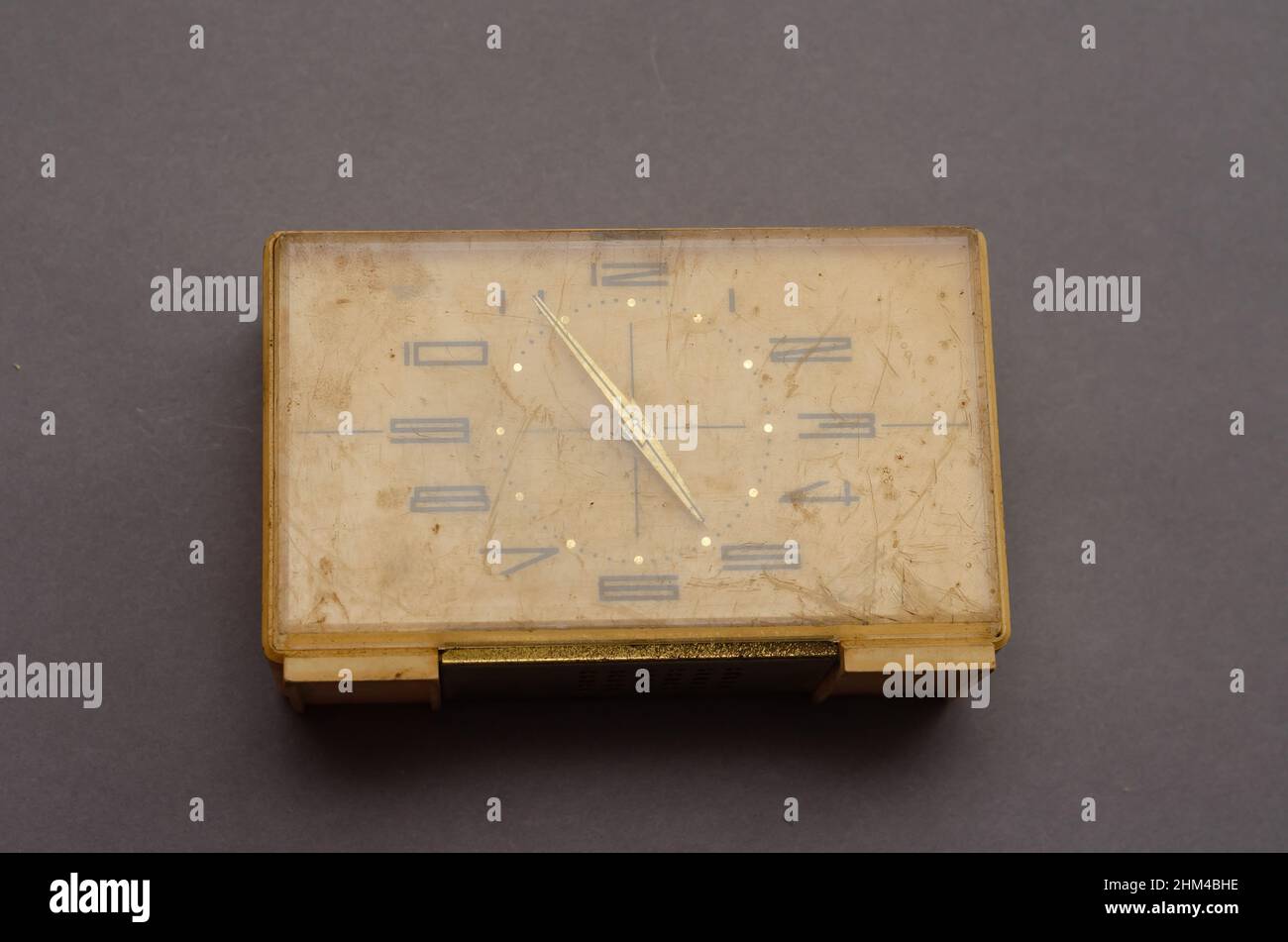 Vintage USSR. An old plastic yellow alarm clock against a gray ...