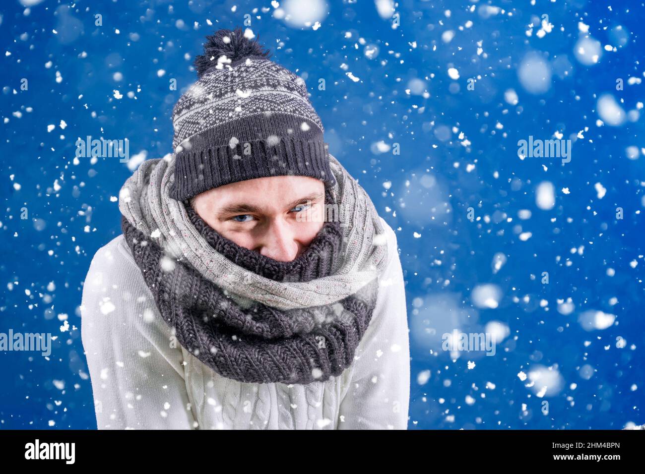 Snow flakes. Coldly. Winter. A frozen guy in a jacket and a scarf under ...