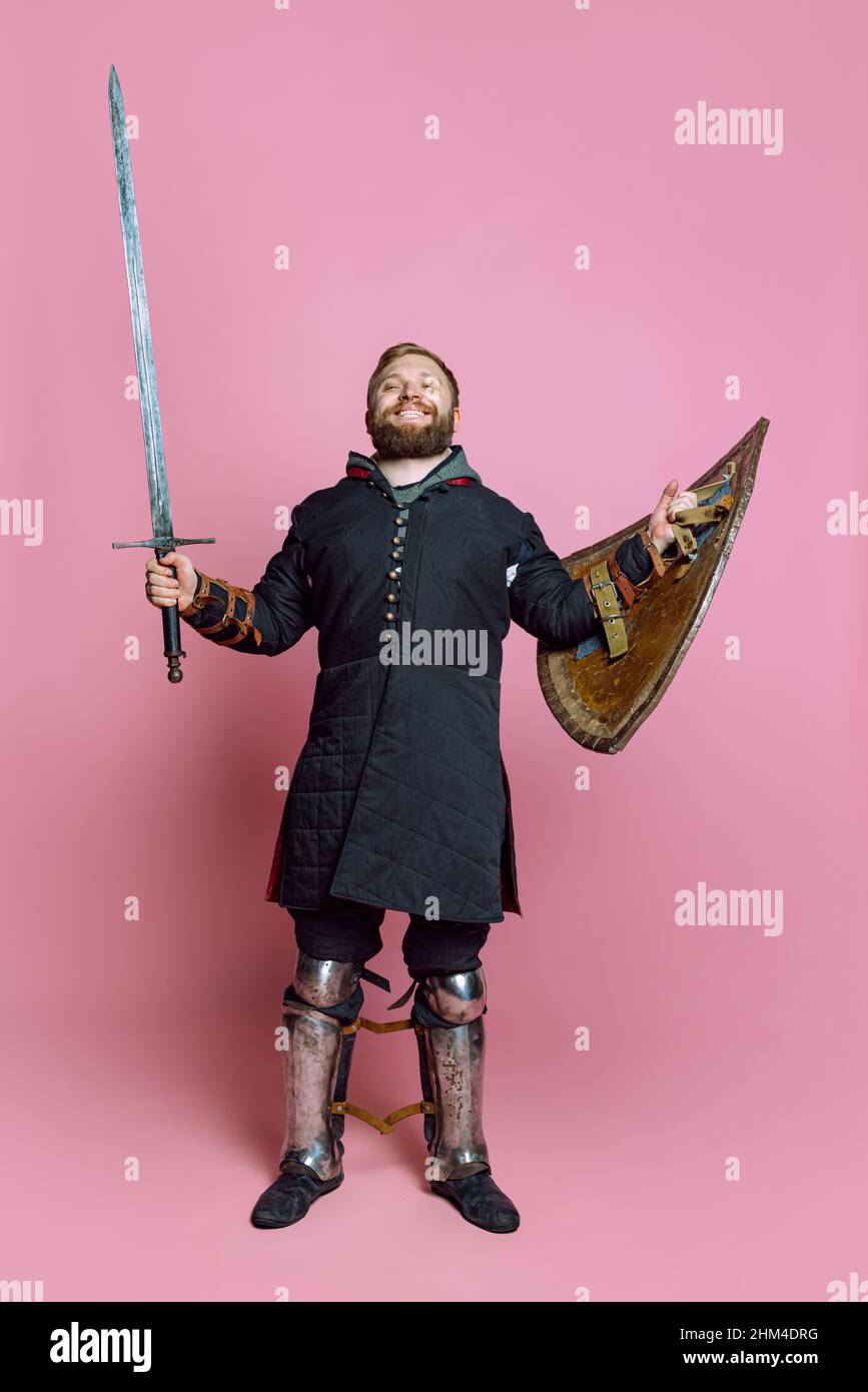 Full-length portrait of young smiling man, medieval warrior or archer ...