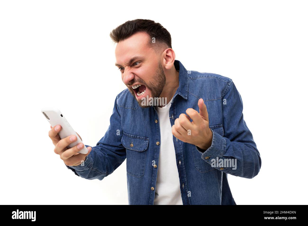 angry man yells at the phone screen, gesturing with his hands with his ...