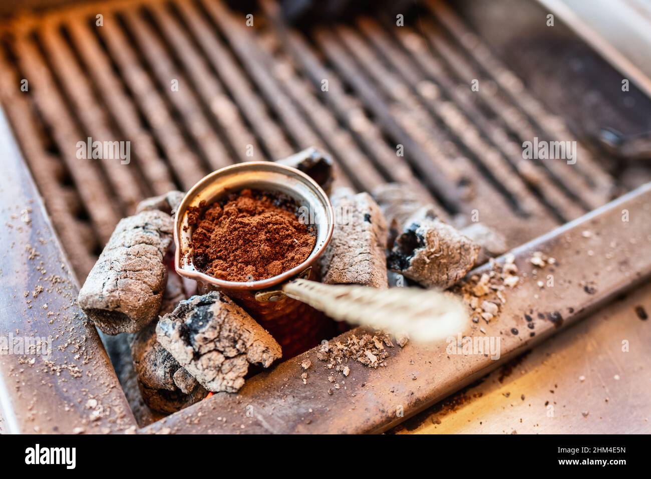 Brewing a turkish style coffee in brassy cezve on a charcoal stove in ...