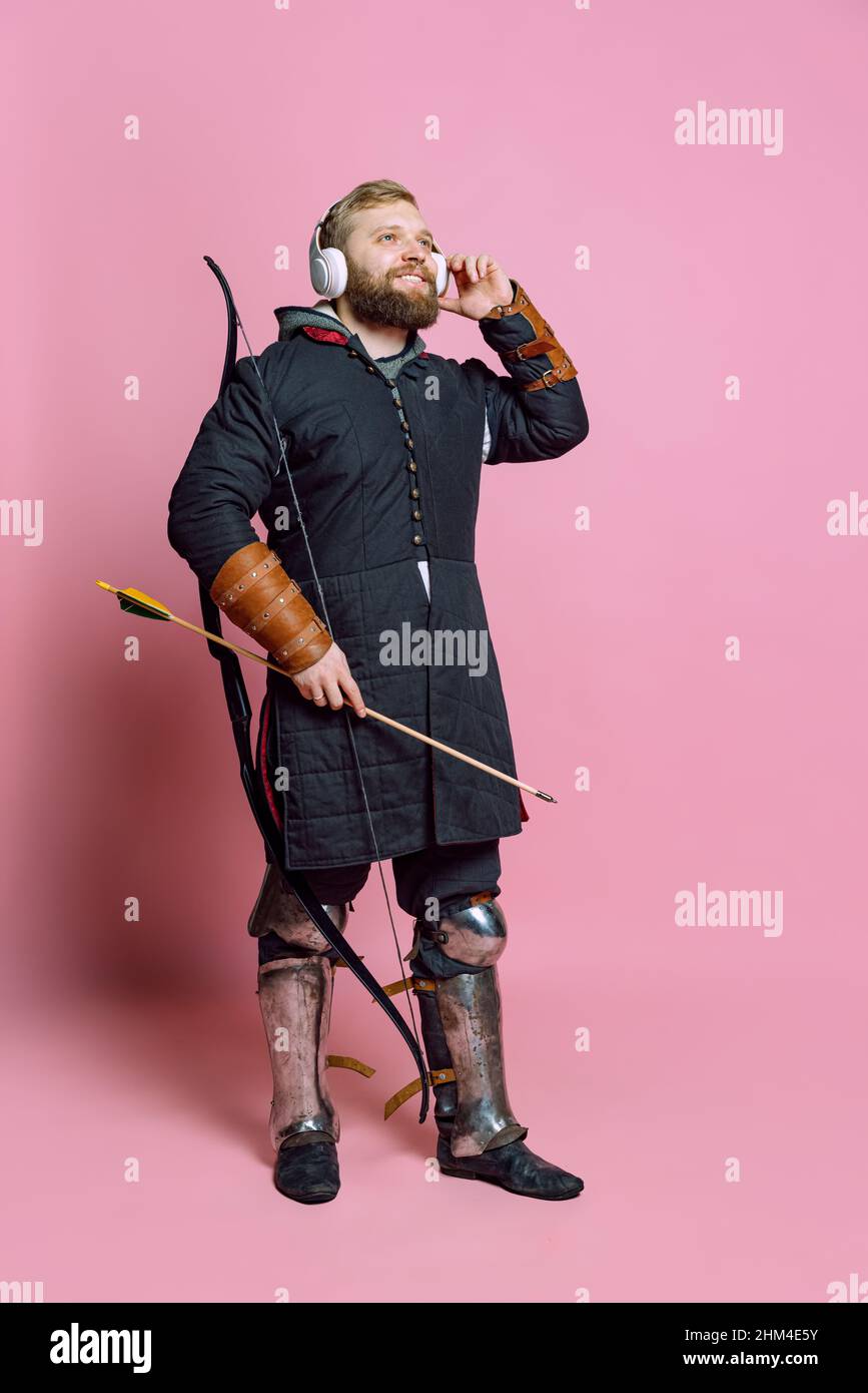 Portrait of young bearded man in image of medieval warrior, archer in ...