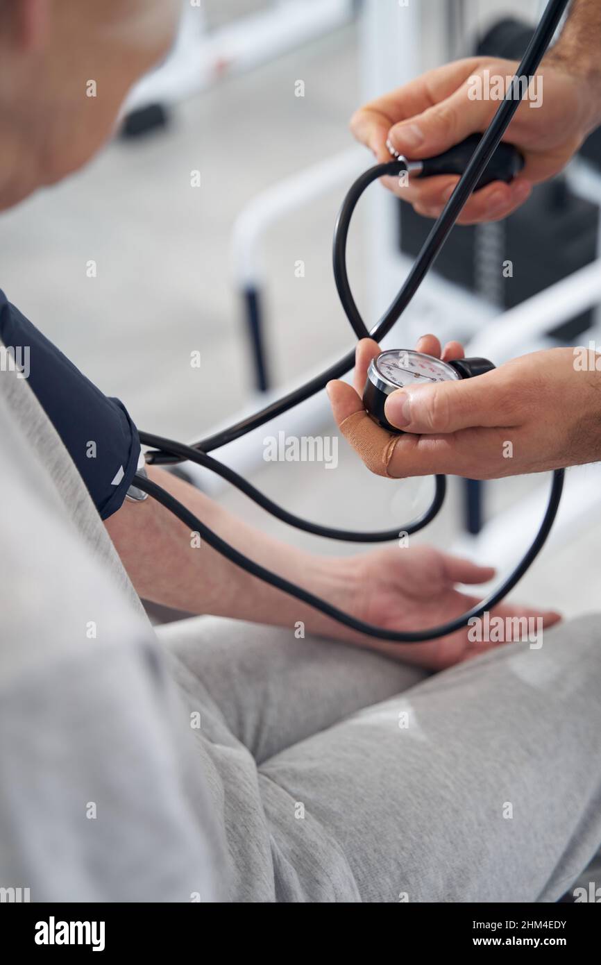 Doctor checking values on blood pressure monitor Stock Photo - Alamy