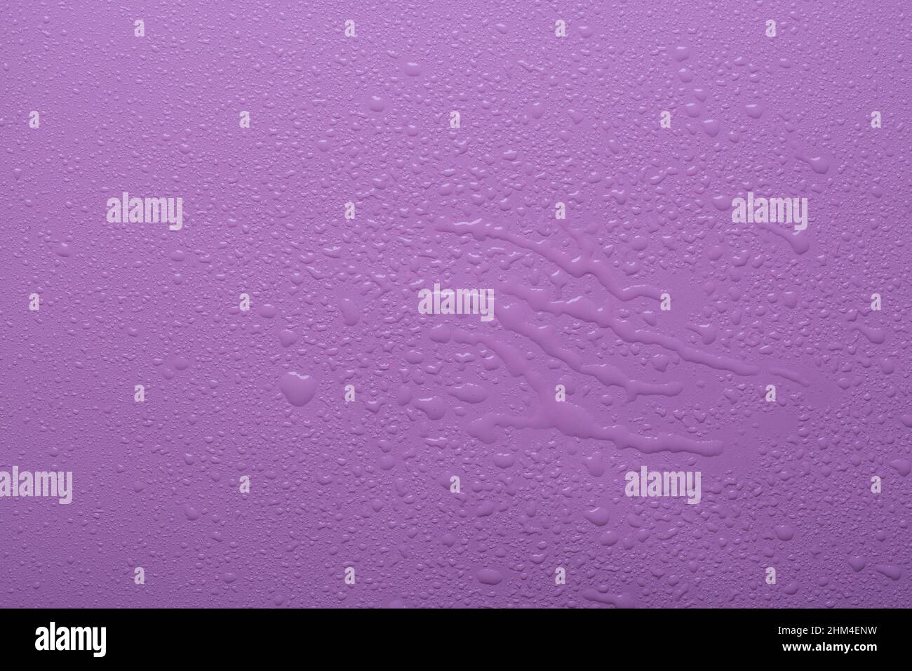 Water drops on purple color surface Stock Photo - Alamy
