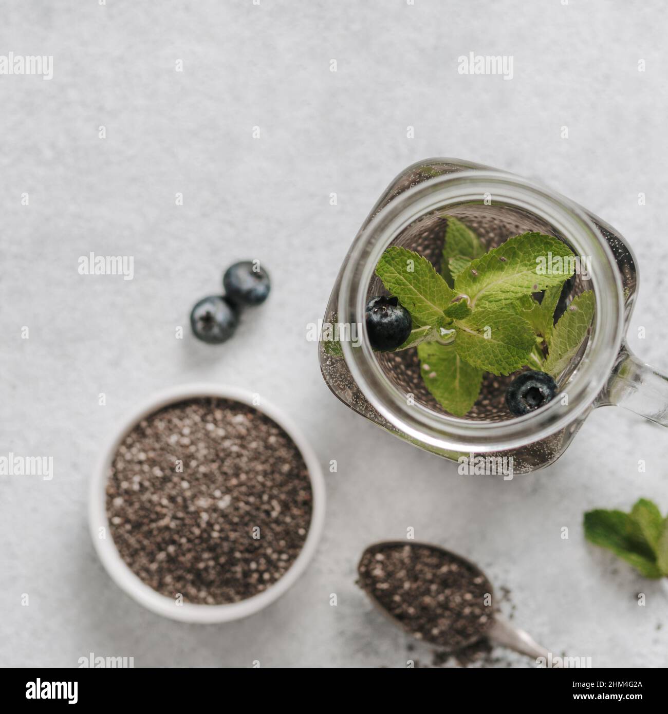 View from above chia water in mason jar with mint and blueberry on gray ...