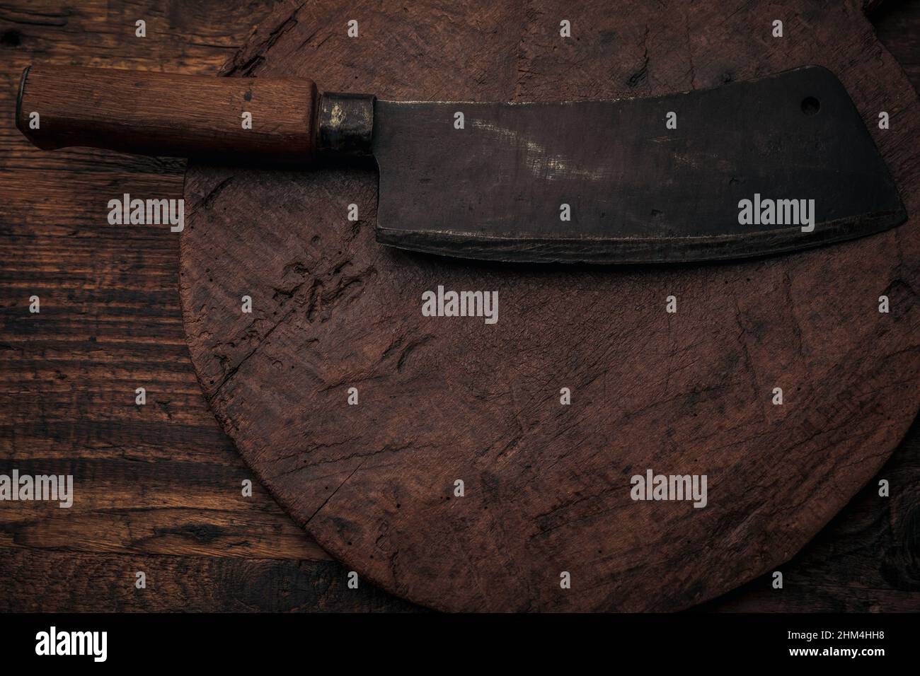 vintage rusty meat cleaver on top of an old wooden table with copy ...