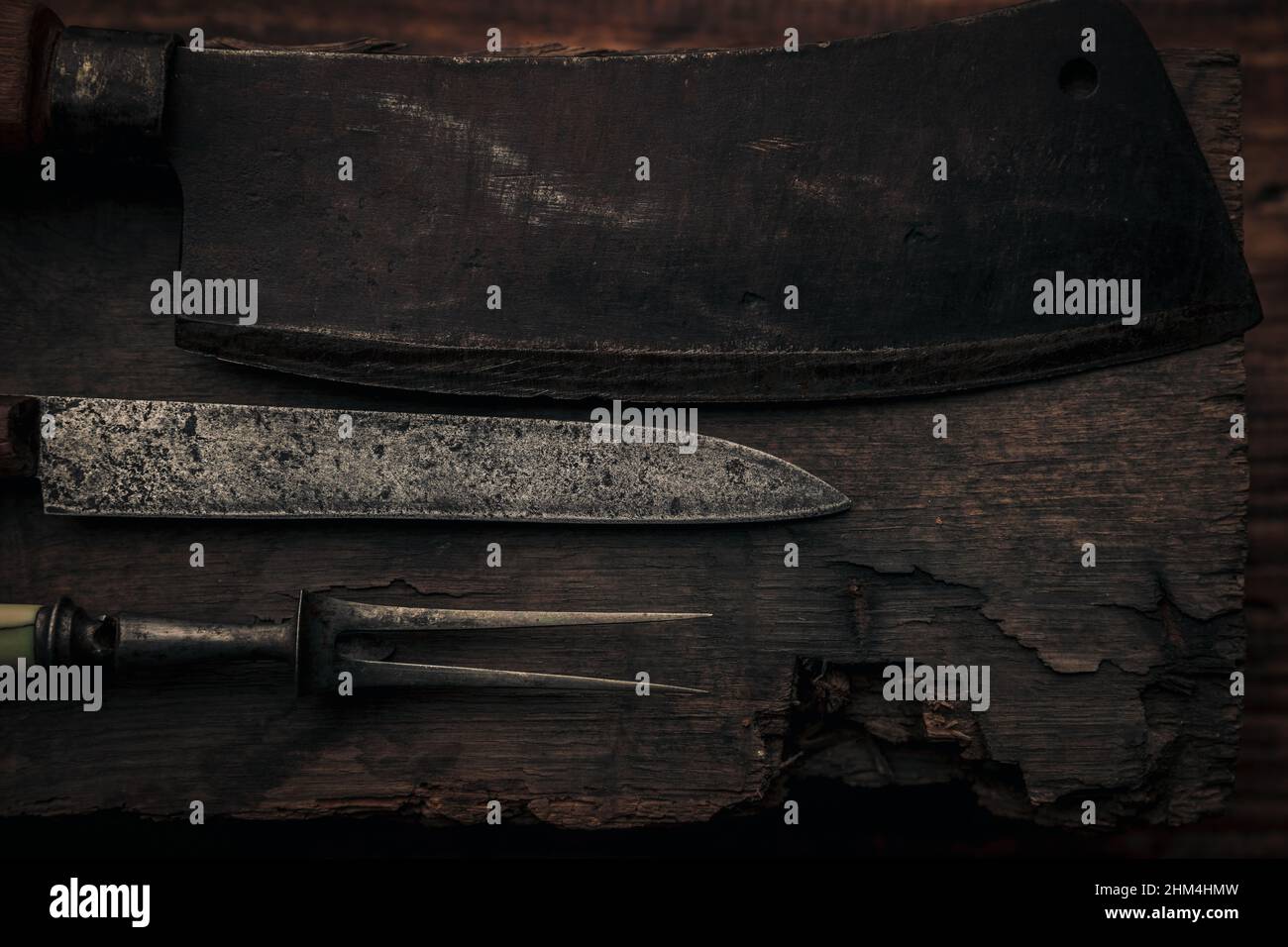 different vintage utensils for cooking meat on an old wood board, all ...