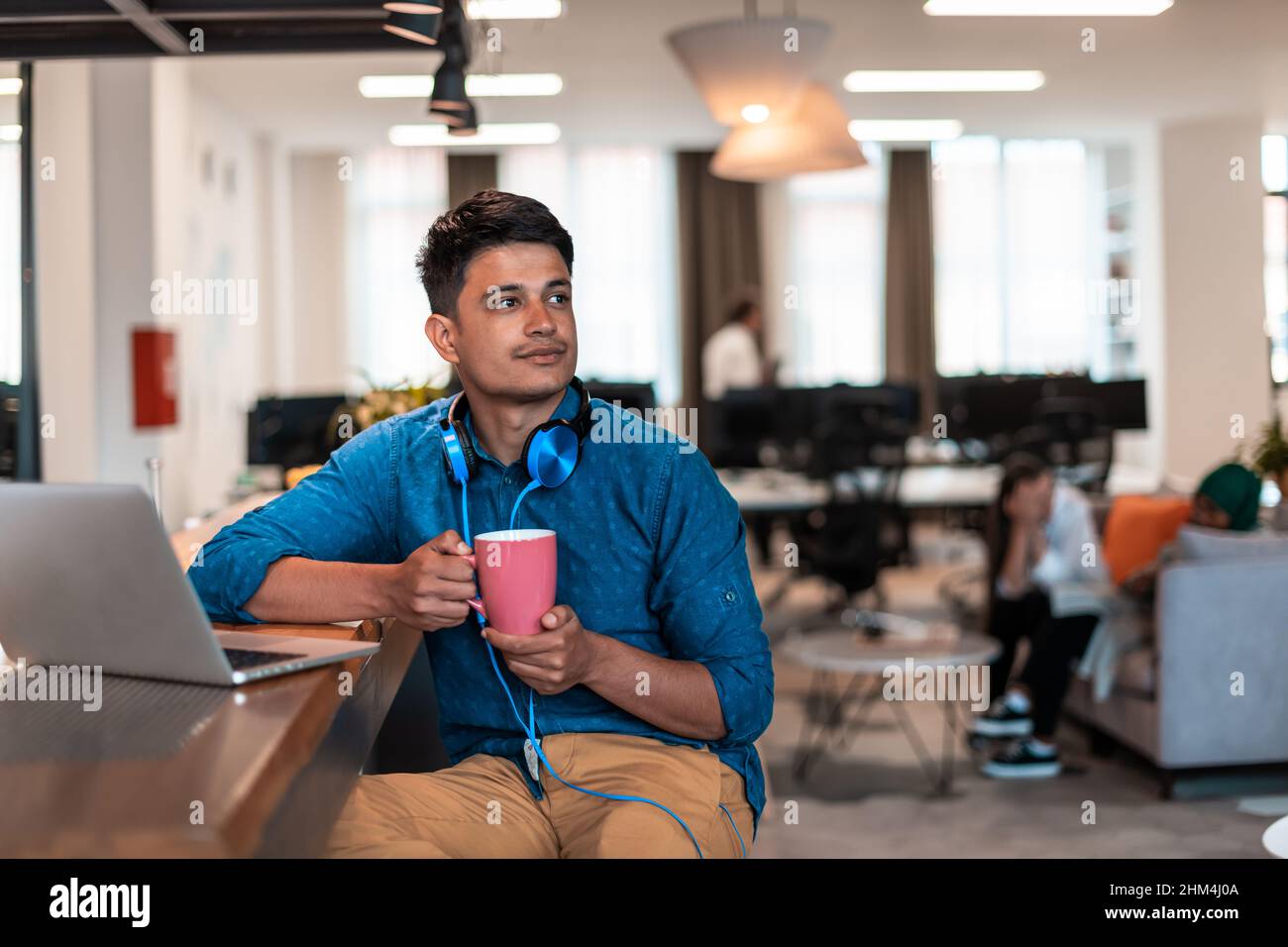 Casual business man taking break from the work using laptop while ...