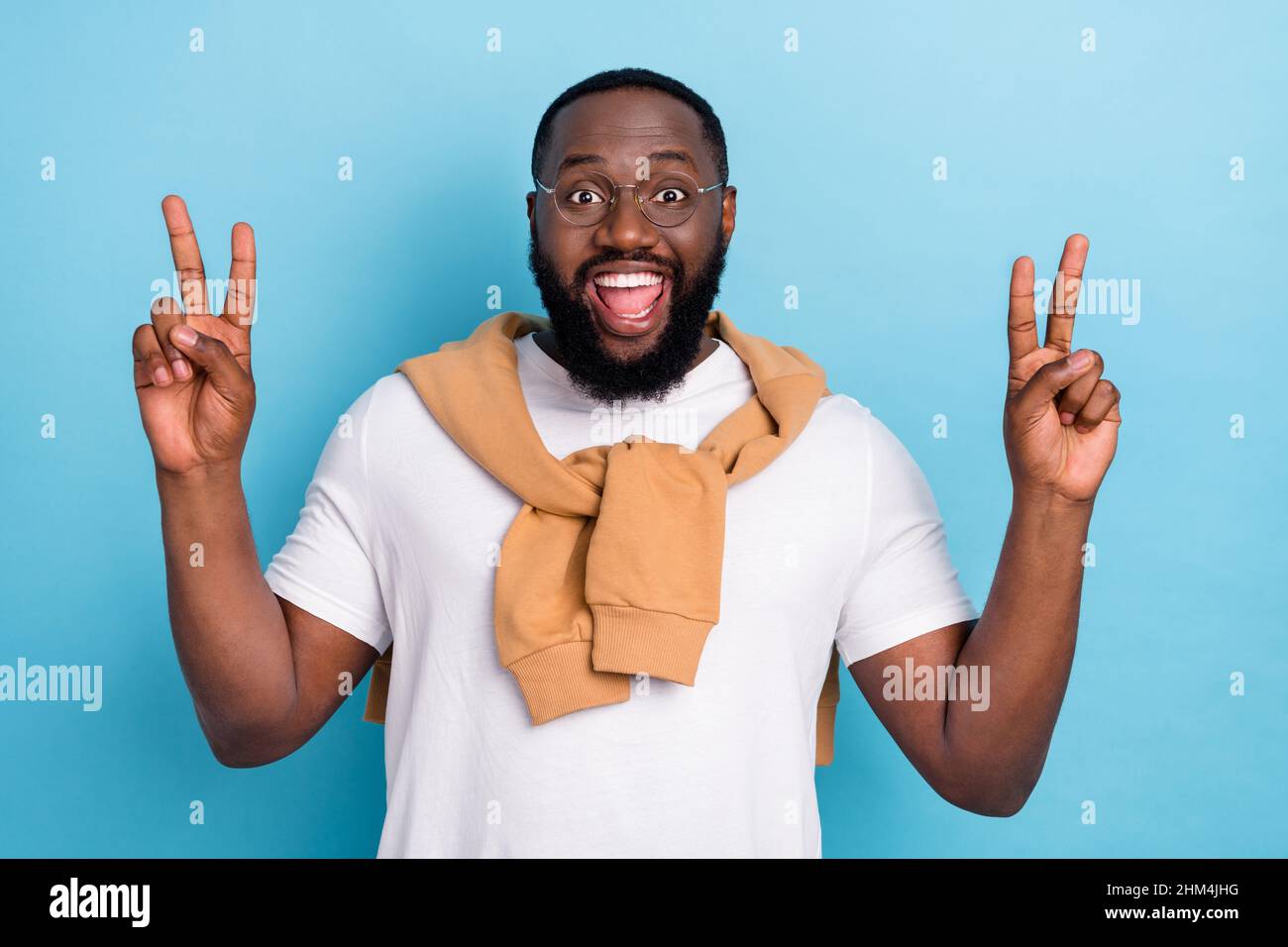Photo of handsome smiling man showing v-sign laughing screaming wear ...