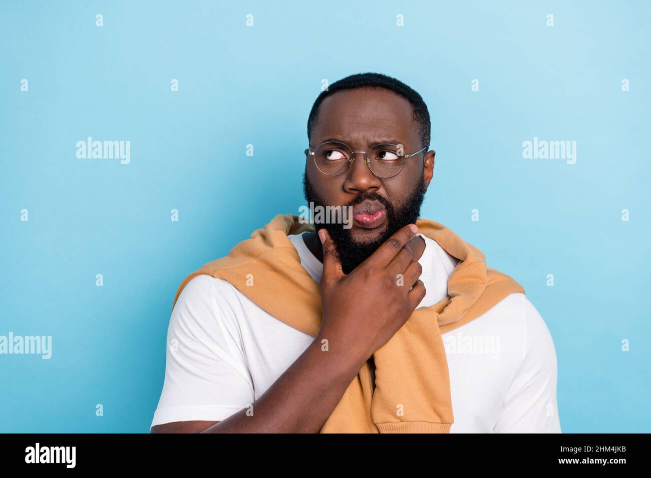 Portrait of young man grumpy face imagine brainstorming look copyspace ...
