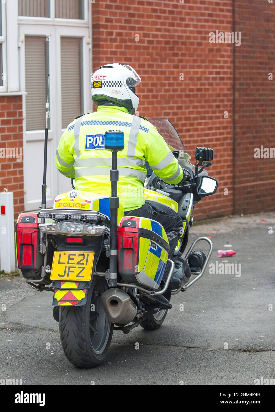 Close, rear view of isolated West Mercia police officer riding a ...