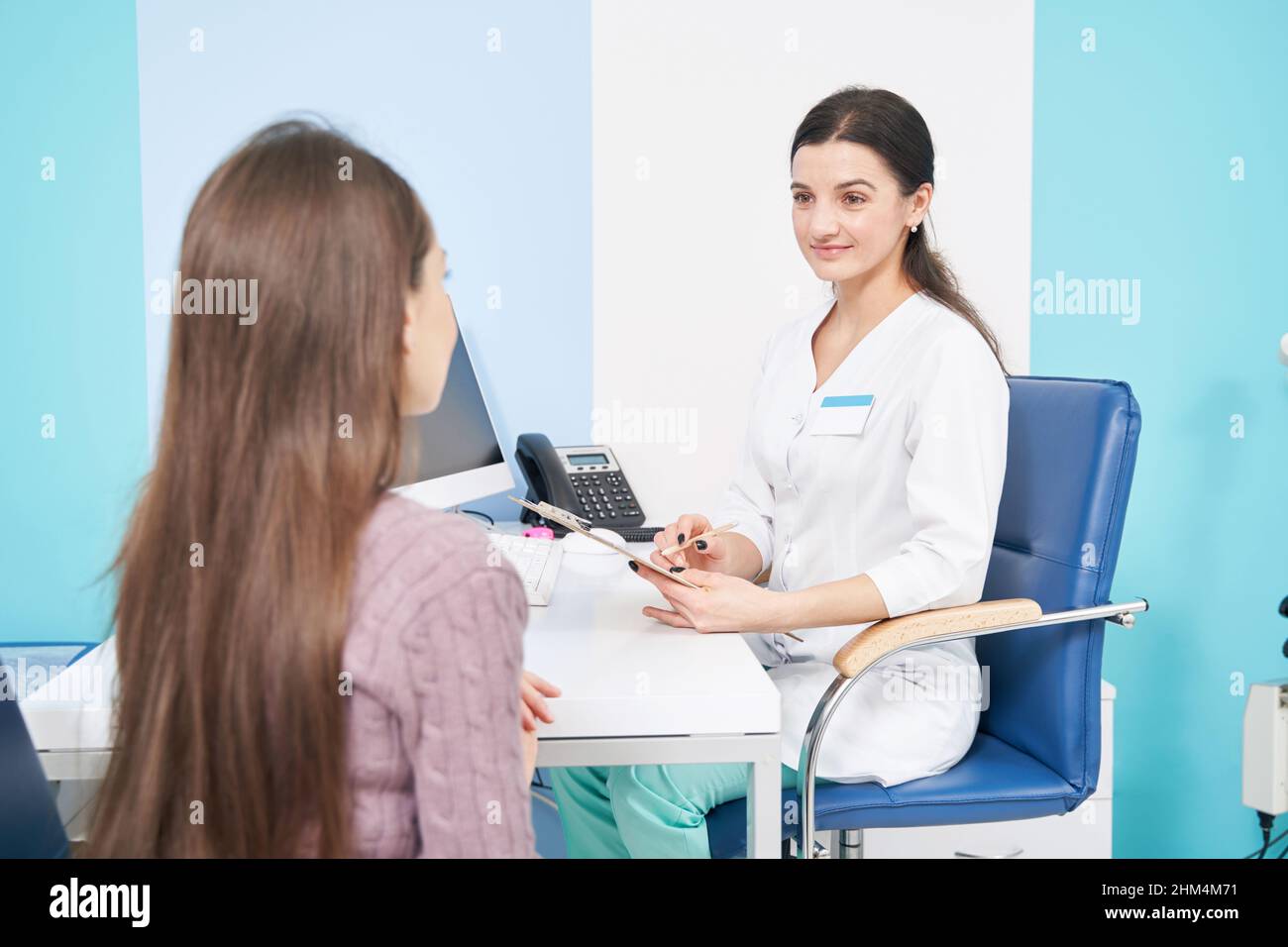 Attentive friendly professional physician receiving female client Stock ...