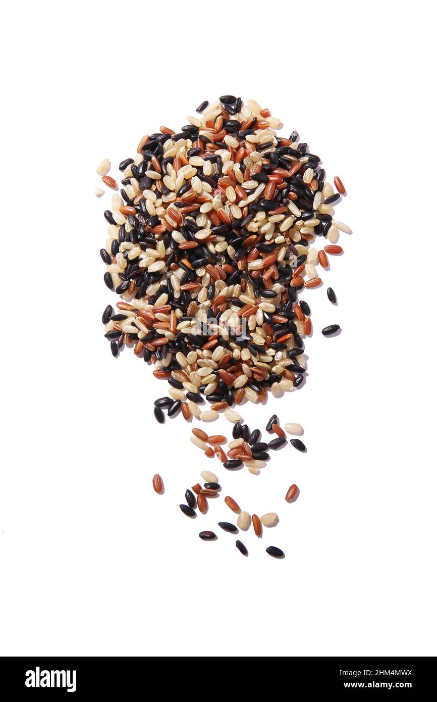 Three different colors of rice mixed together on a white background ...