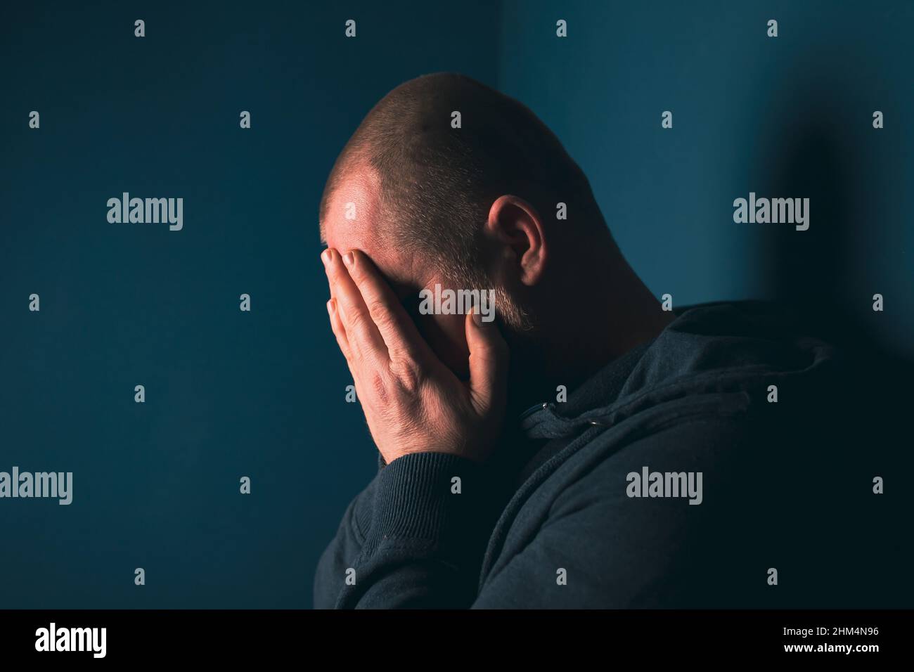 Sad man sitting in dark hi-res stock photography and images - Alamy