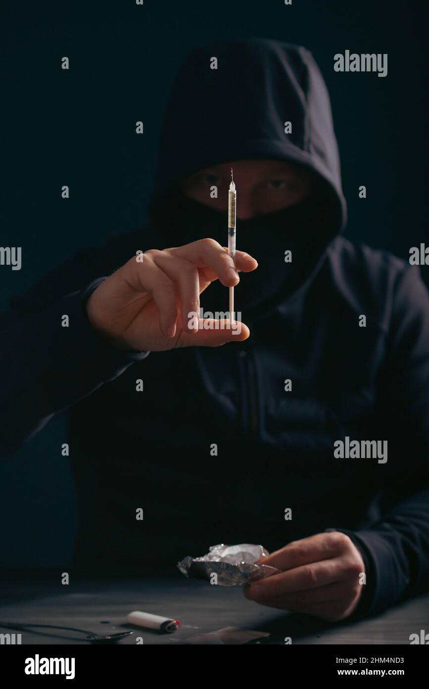 Addict/junkie man preparing drugs. The concept of crime and drug ...