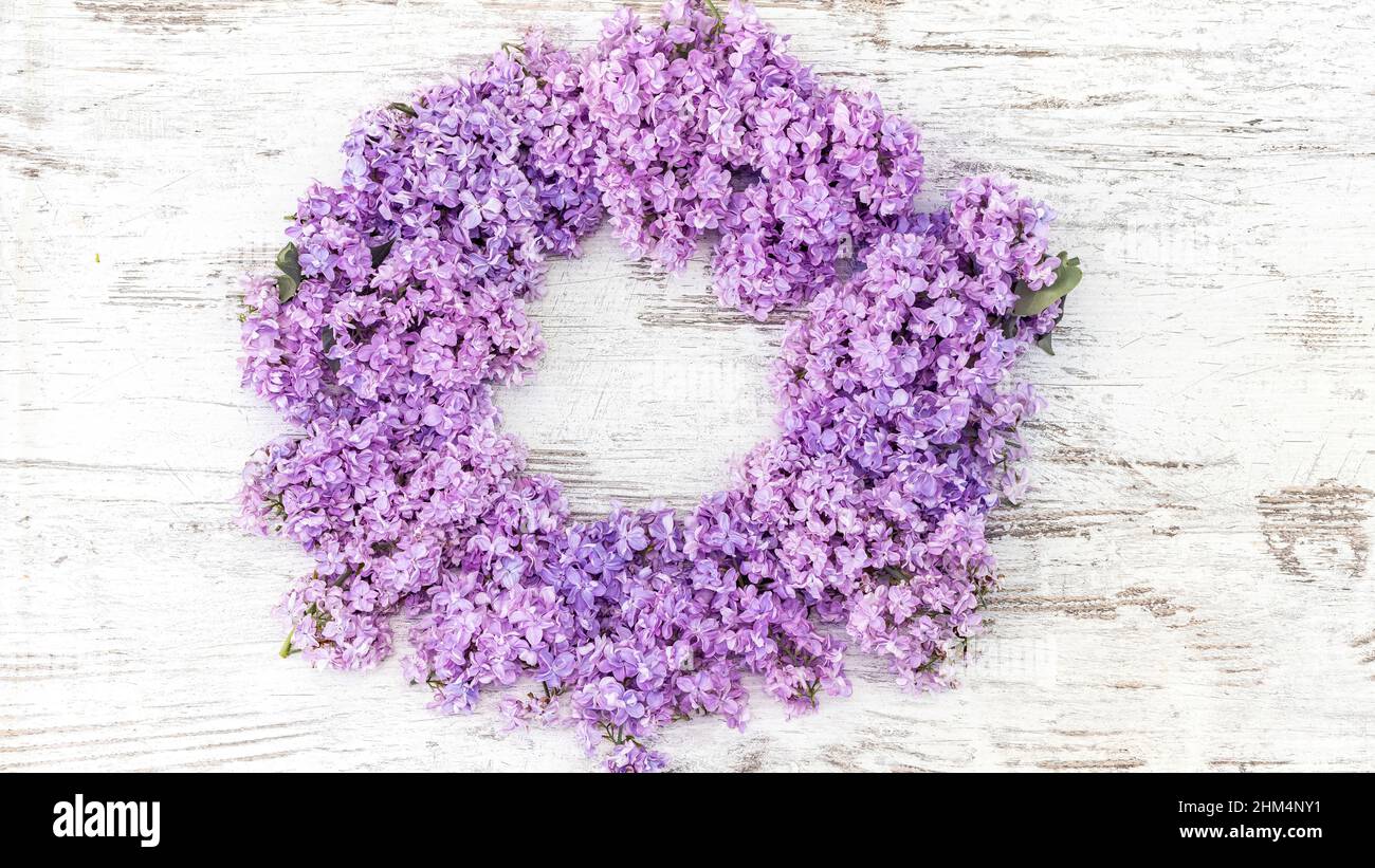 Lilac wreath banner. Lilac flowers against whitewashed rustic wood with ...