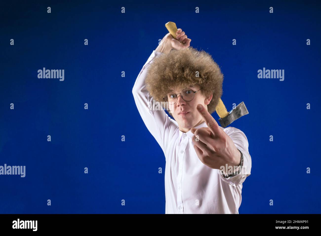 Psychopath. Maniac. Curly-haired man in a white shirt with an ax in his ...