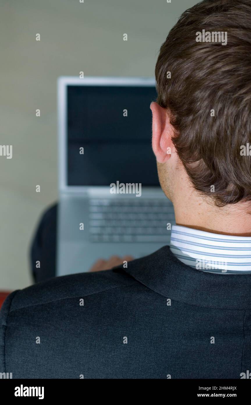 Rear View Of A Businessman Using A Laptop, Credit:Photoshot Creative ...