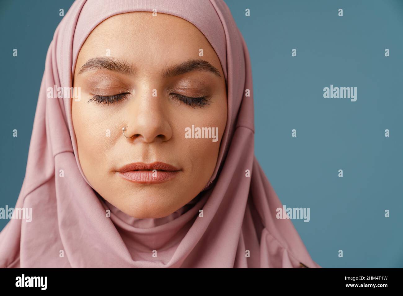 Young Muslim Woman In Hijab Posing With Her Eyes Closed Isolated Over