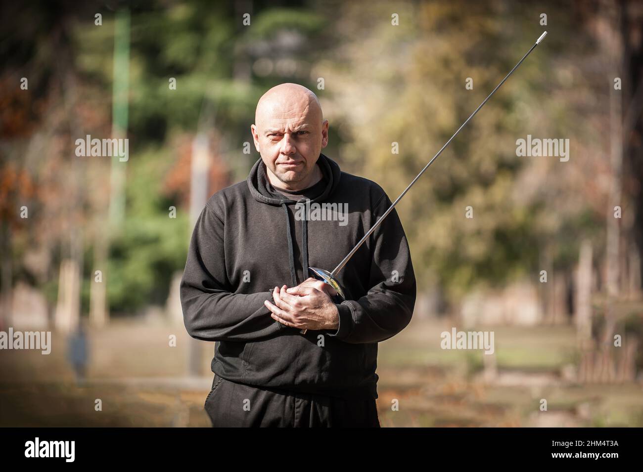 Fencing swordsman instructor demonstrates sword fighting techniques and ...