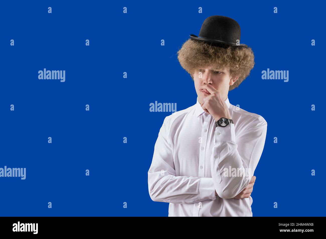 The handsome curly-haired man in a small hat pondered. Humor. Cool guy ...