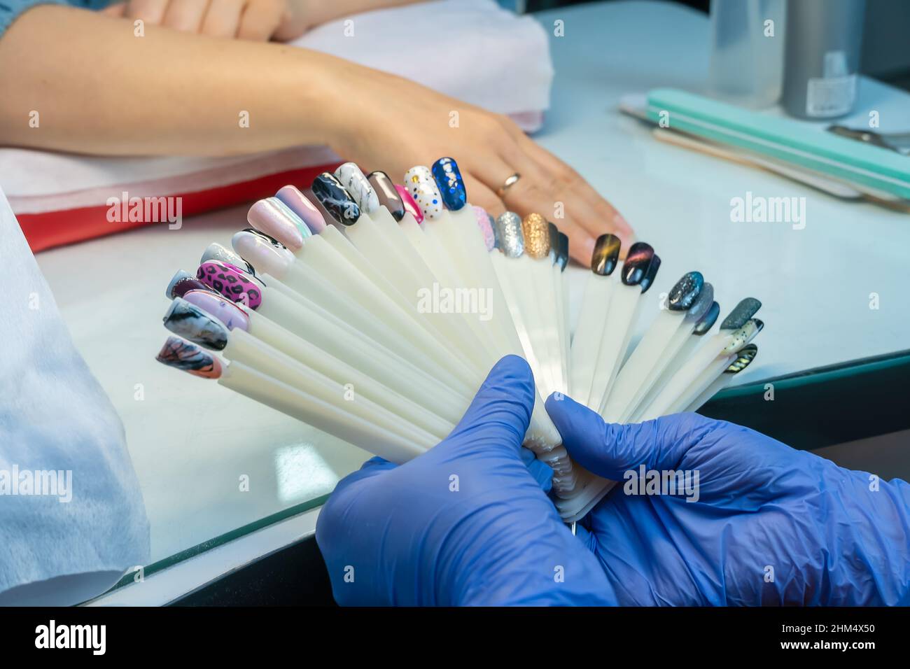 Manicure master shows the color palette of the client 's choice for ...