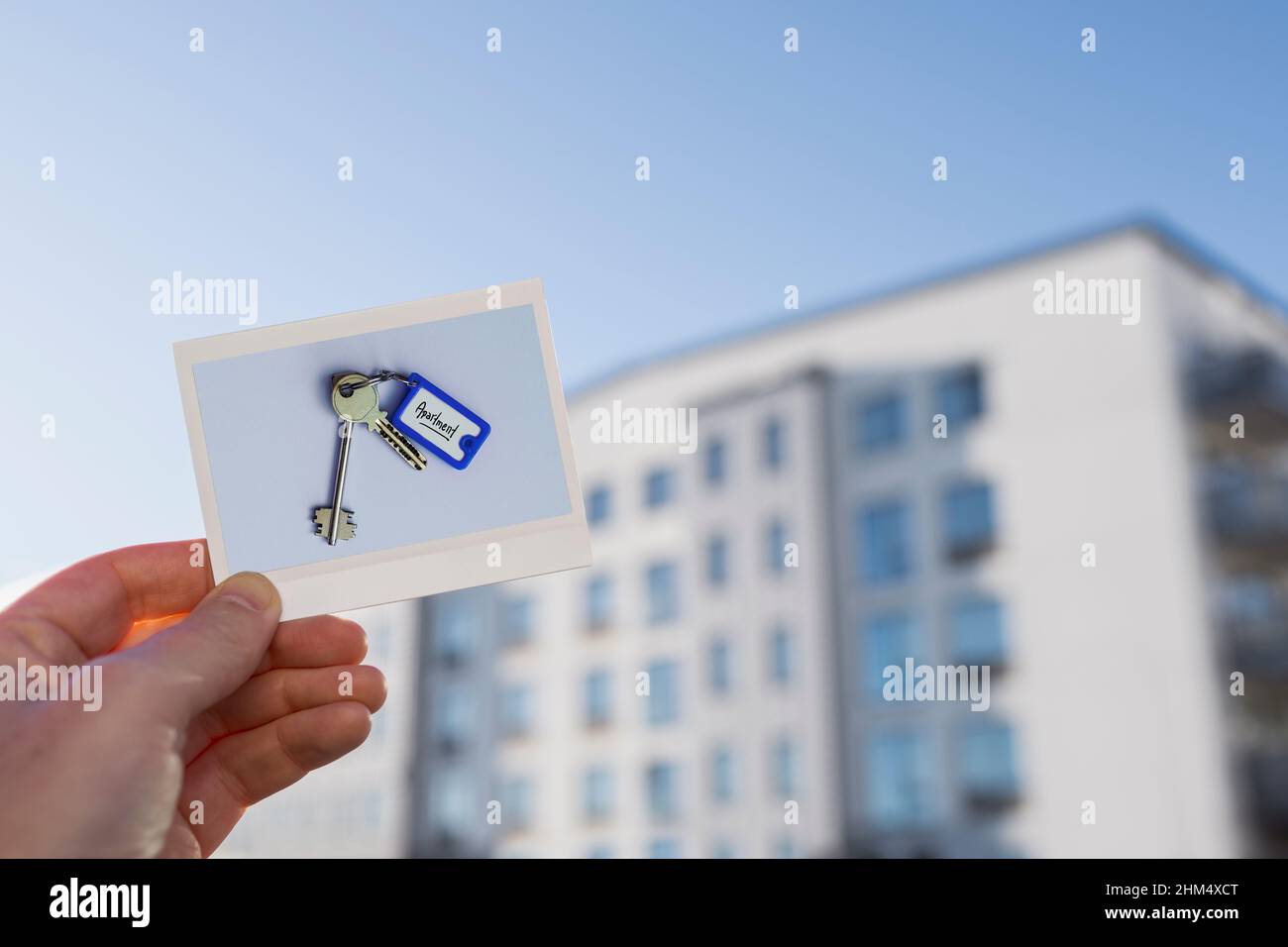 Hand holding photo of keys in front of building Stock Photo - Alamy