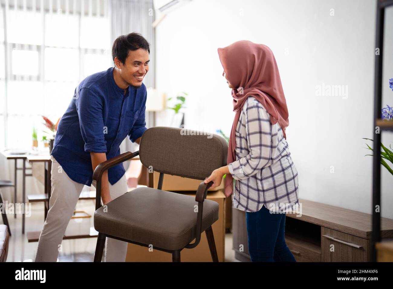 muslim young couple moving new chair at their new home Stock Photo - Alamy