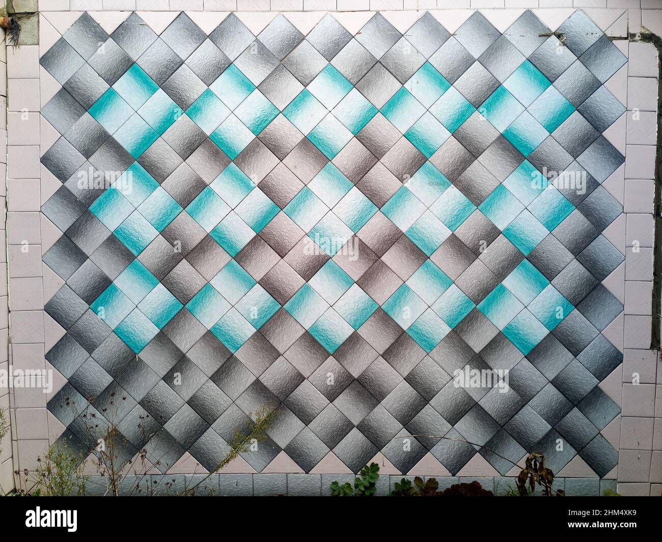 Old tile on the wall. The background texture of the tile is blue and ...