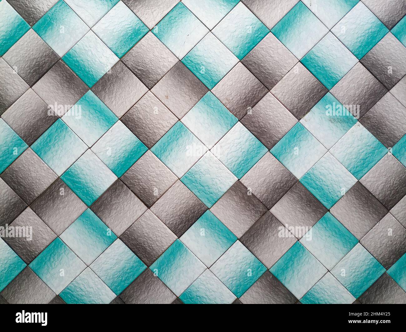 Old tile on the wall. The background texture of the tile is blue and ...