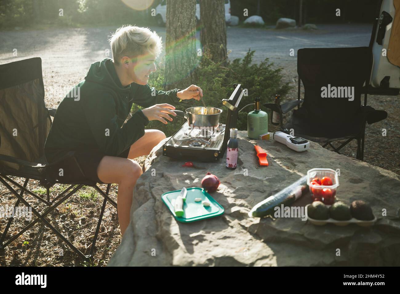 Woman cooking food at campsite Stock Photo - Alamy