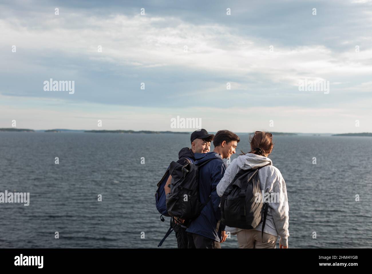 Friends standing together at sea Stock Photo - Alamy