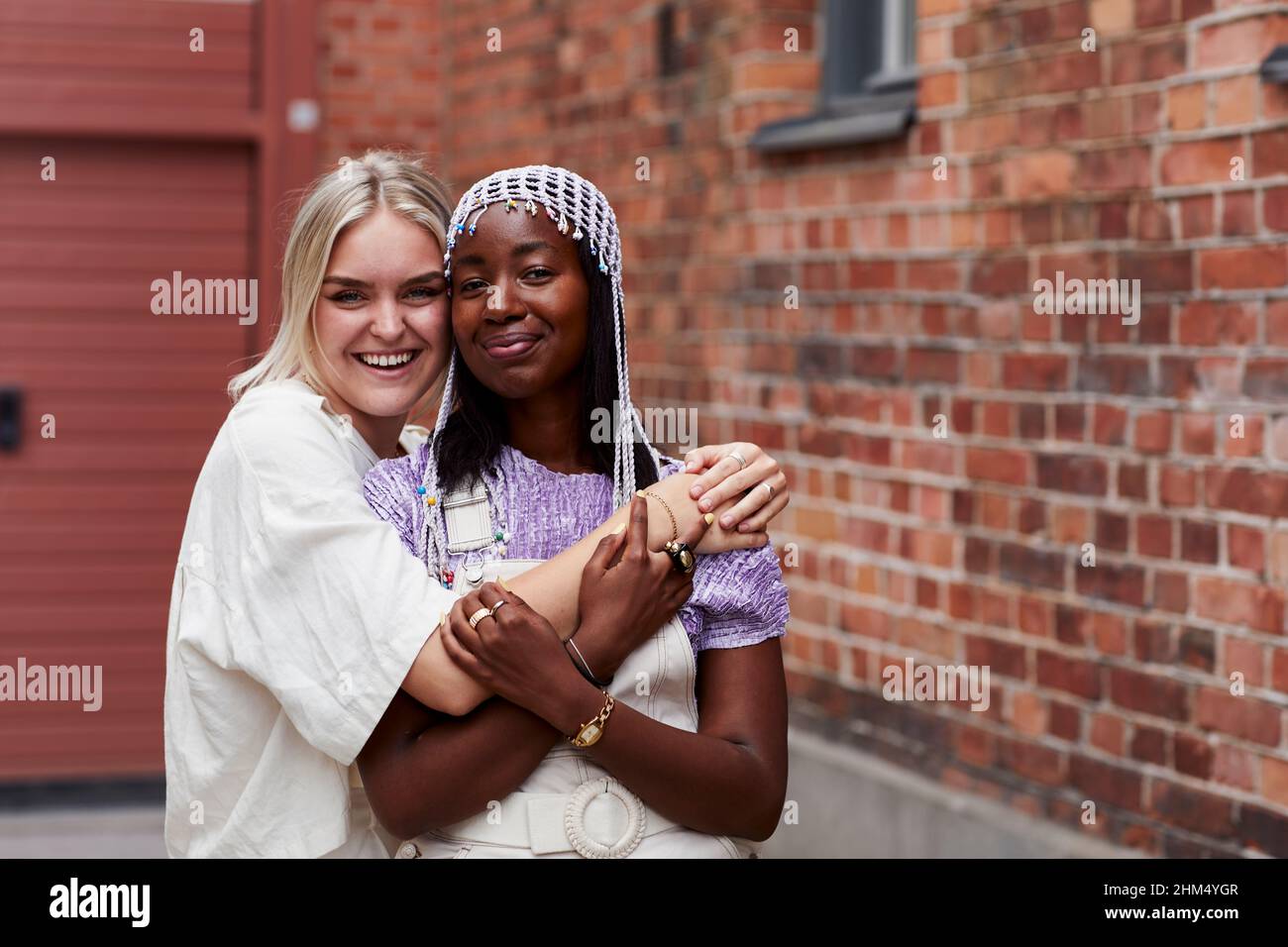 Smiling friends looking at camera Stock Photo - Alamy
