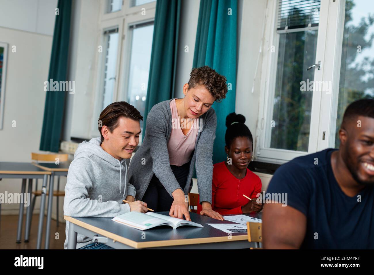 Female teacher helping student Stock Photo - Alamy