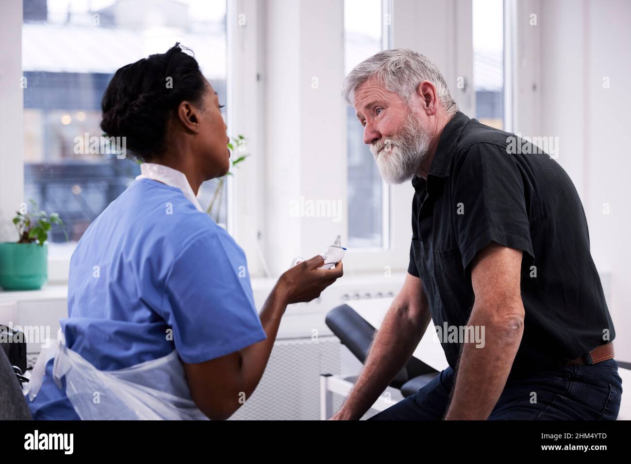 Female doctor talking to senior patient Stock Photo - Alamy