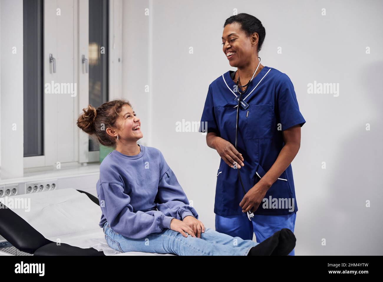 Girl patient and female doctor laughing during appointment Stock Photo ...