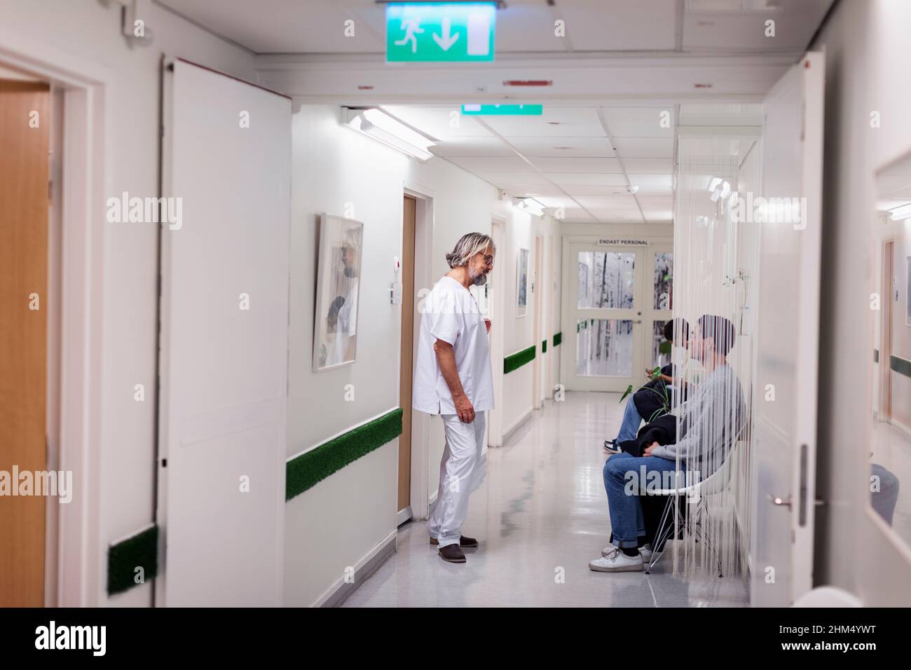Doctor talking to patient in hospital corridor Stock Photo - Alamy