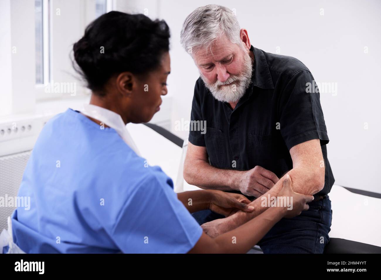 Female doctor examining patient's arm Stock Photo - Alamy