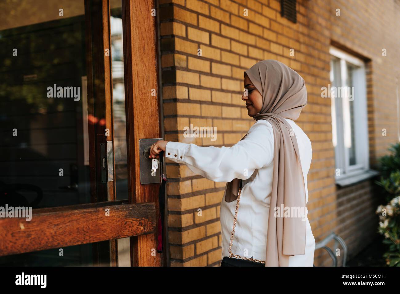 Woman entering building Stock Photo - Alamy