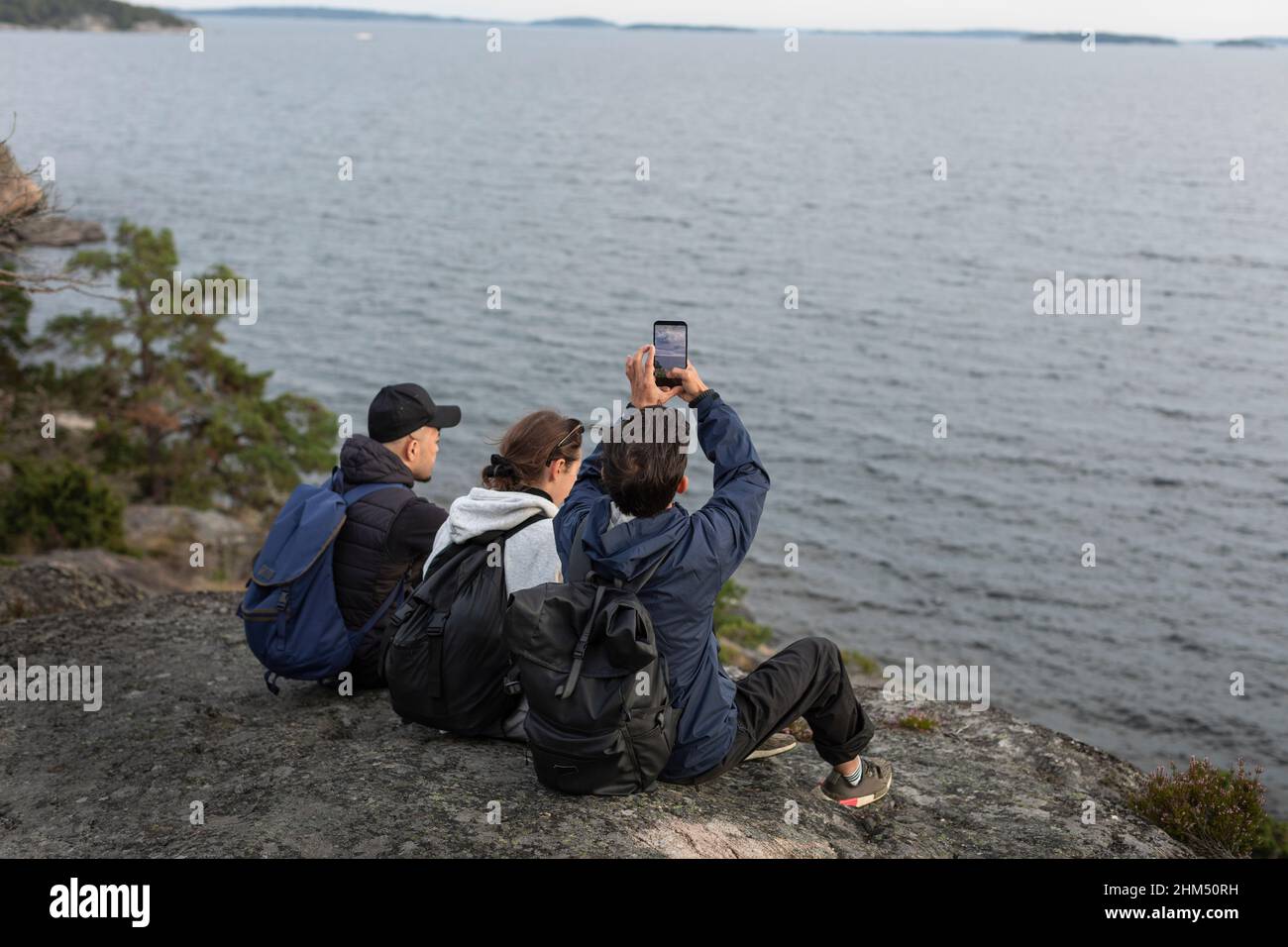 Friends sitting together at sea Stock Photo - Alamy