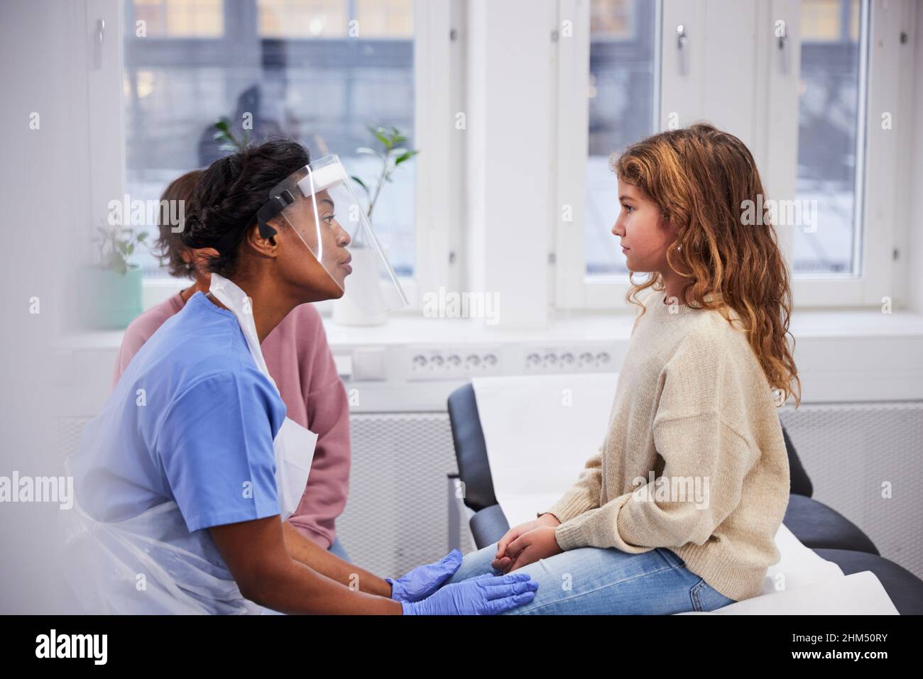 Female doctor talking to girl patient during appointment Stock Photo ...