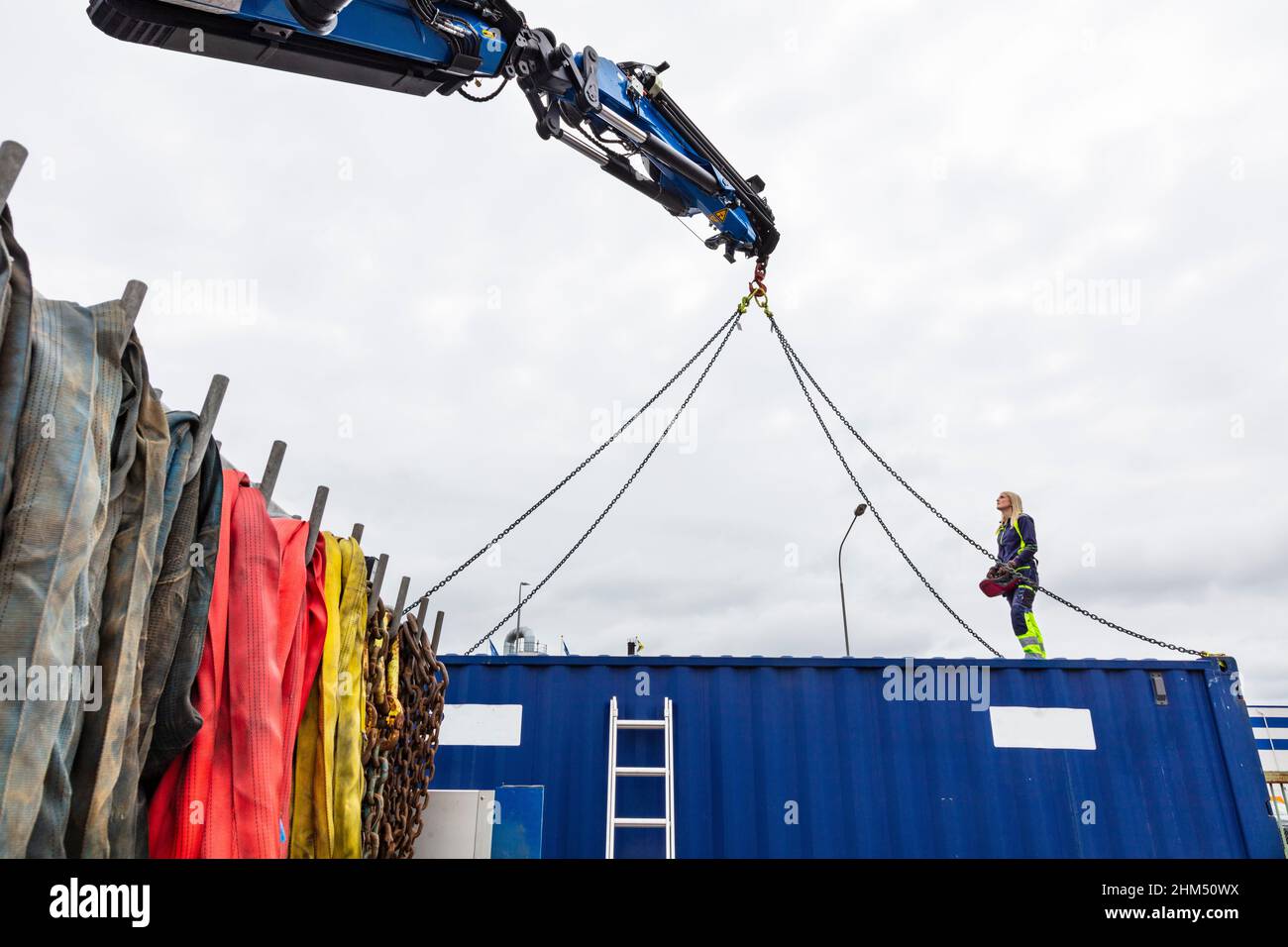 Woman assisting with carrying cargo container Stock Photo - Alamy